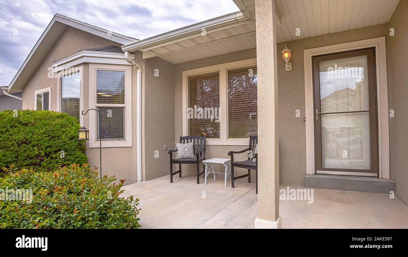 Panorama Chairs and table at the concrete porch of a home with bay ...
