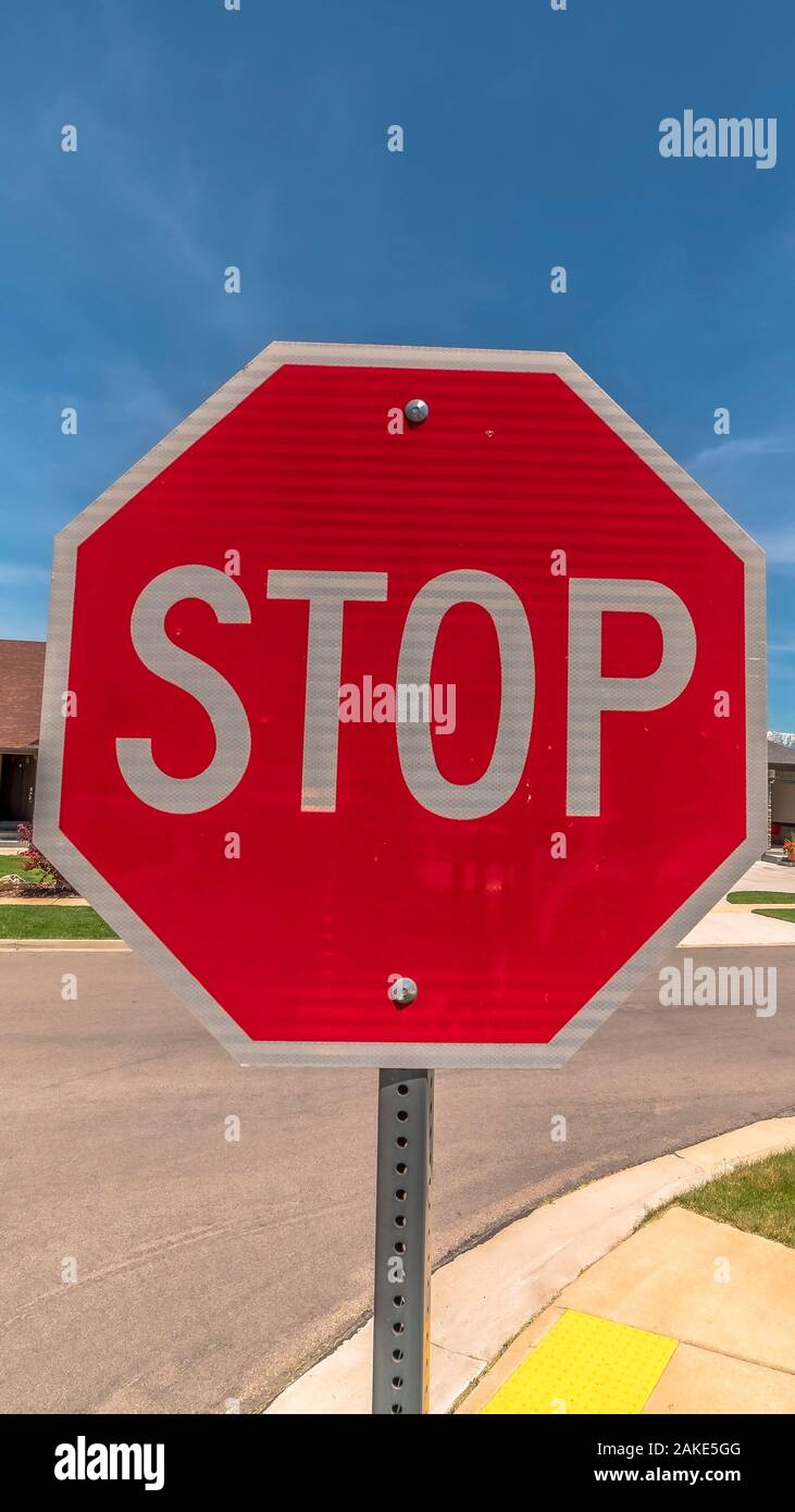 Vertical Selective focus of a red and white stop sign against paved ...
