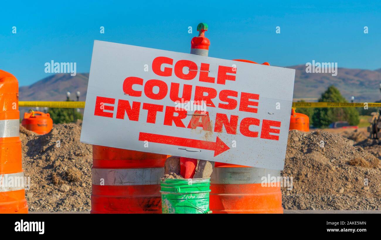 Panorama frame Road under construction with golf course entrance sign ...