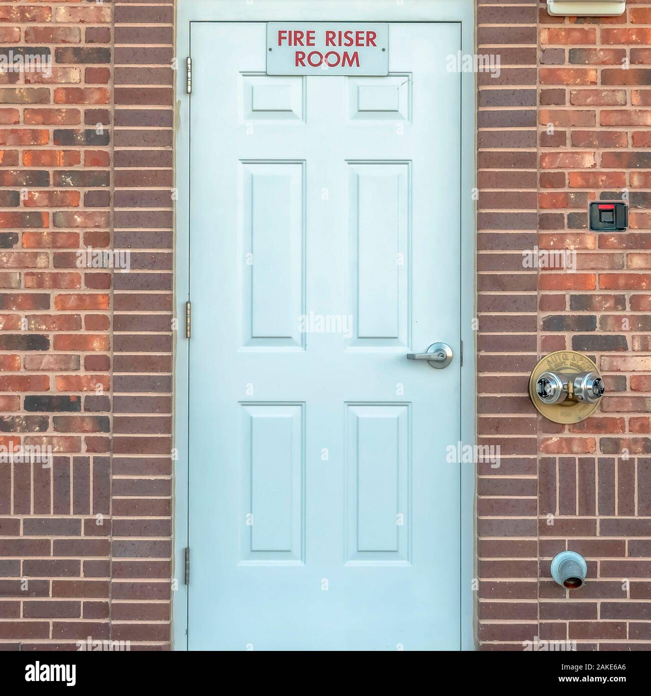 Square frame Fire Riser Room sign on the white wood door of a building ...
