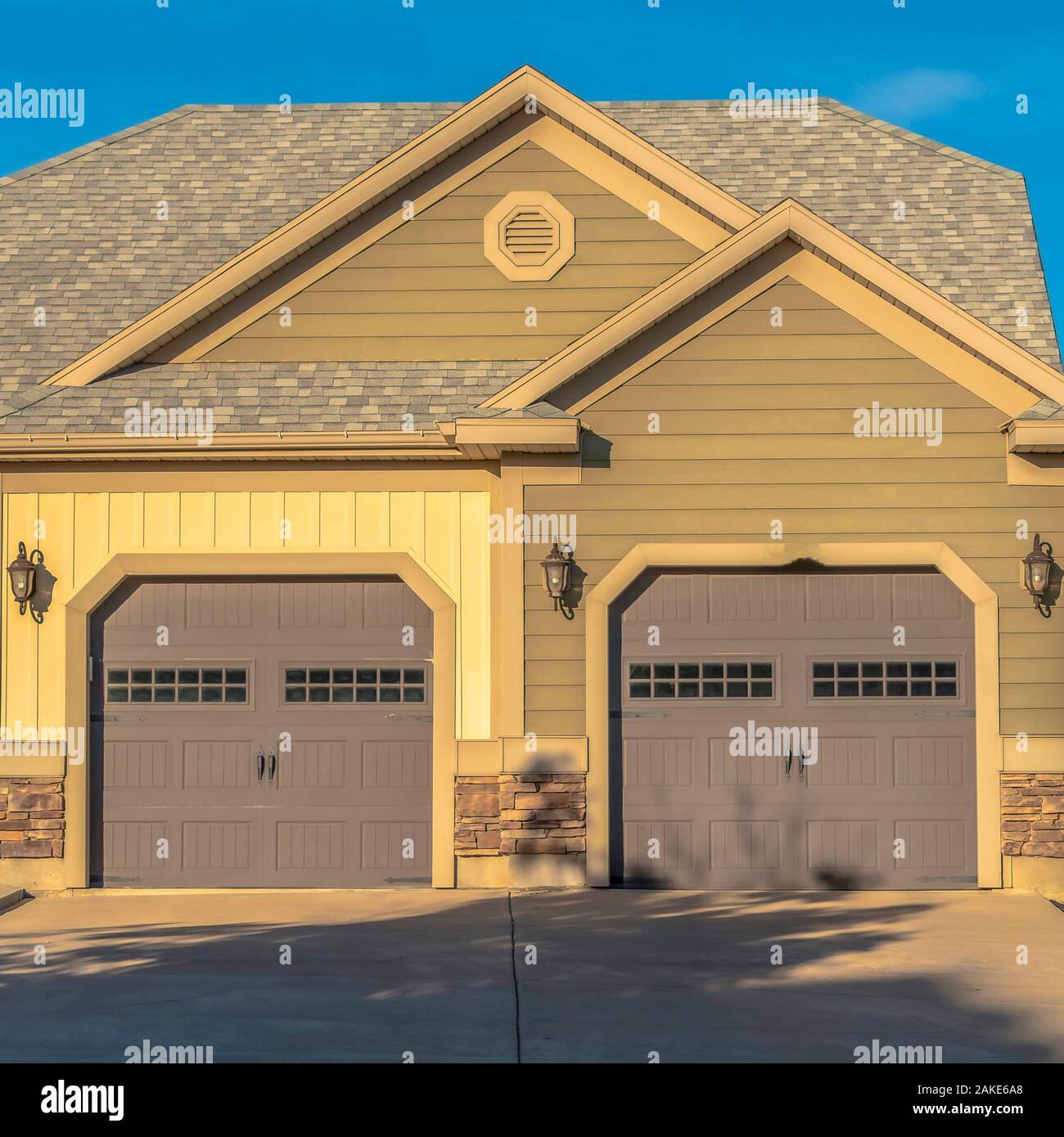 Square Facade of house with view of the gray two car garage against ...