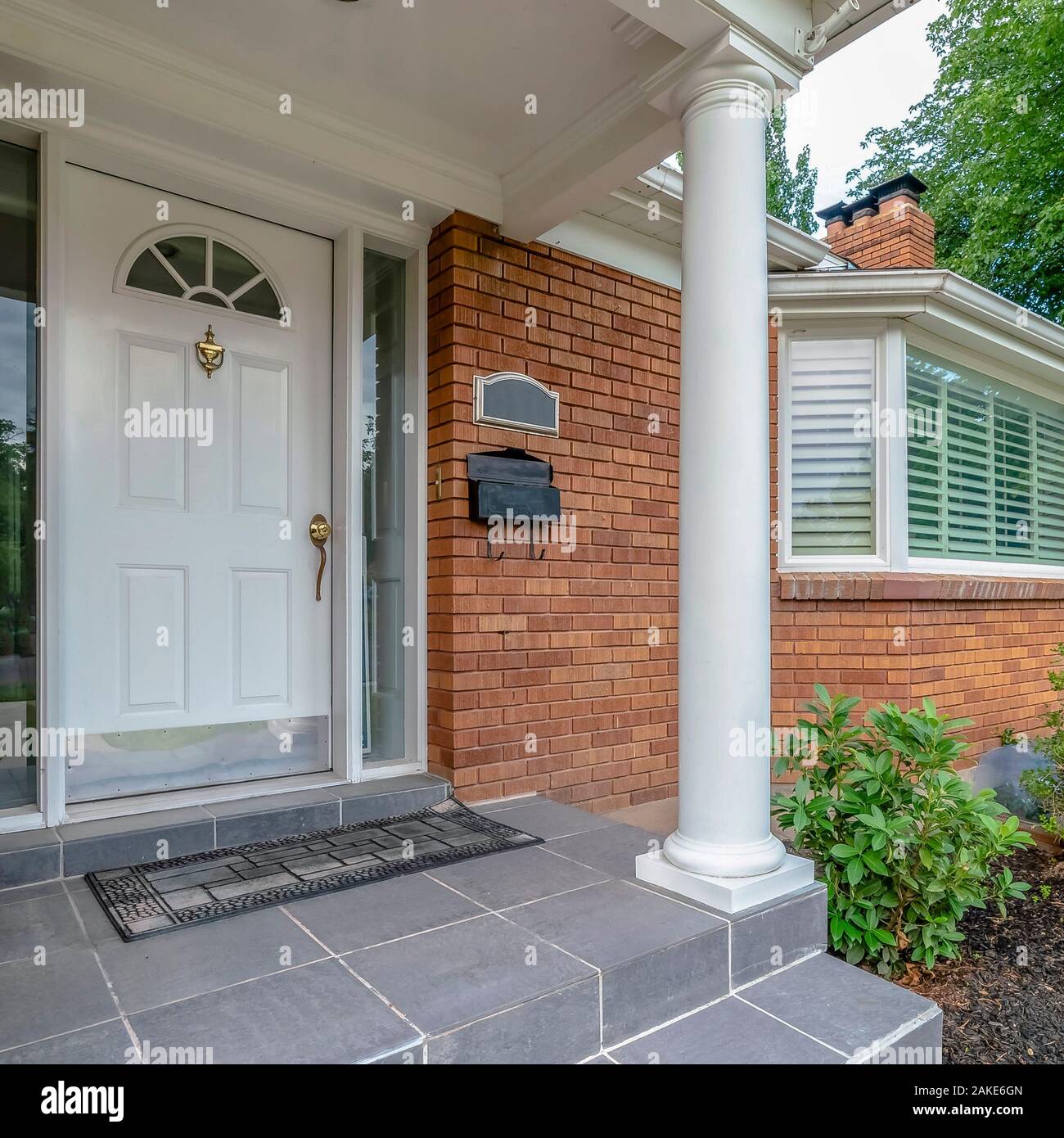 Square Facade of home with brick exterior wall porch bay windows and ...