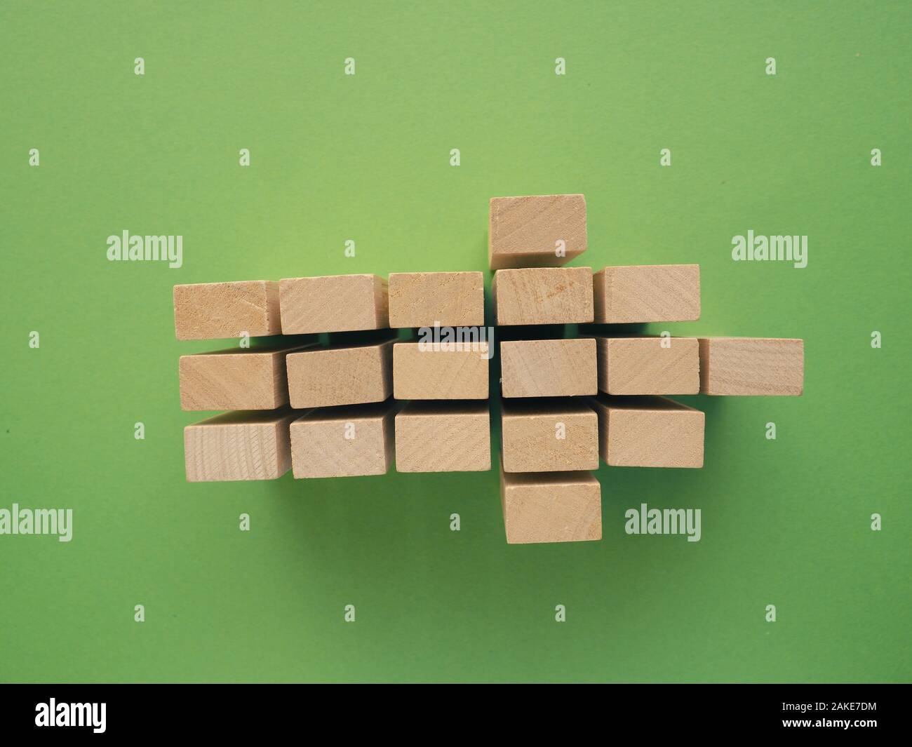 Arrow shape with wooden blocks on a green paper background Stock Photo ...