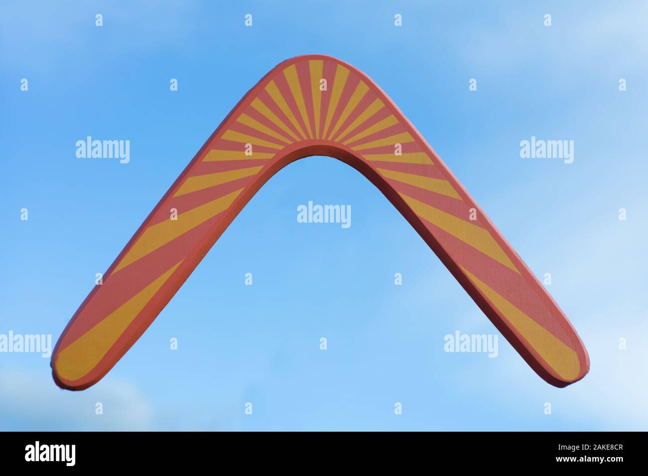 Wooden australian boomerang in flight against of pure white clouds and ...