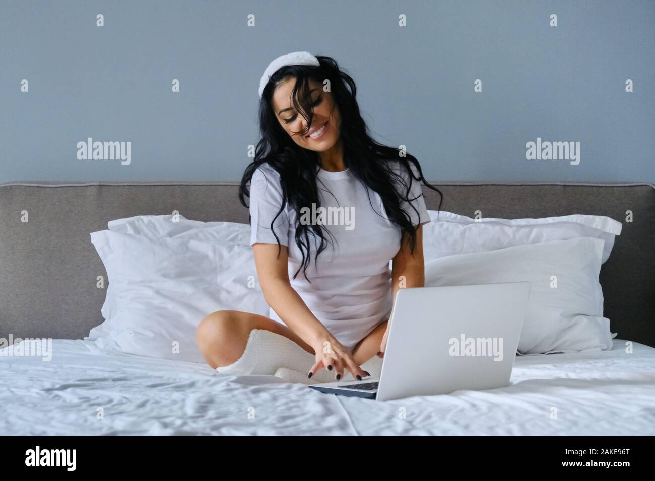 Beautiful woman blogger sitting in bed with computer laptop Stock Photo ...