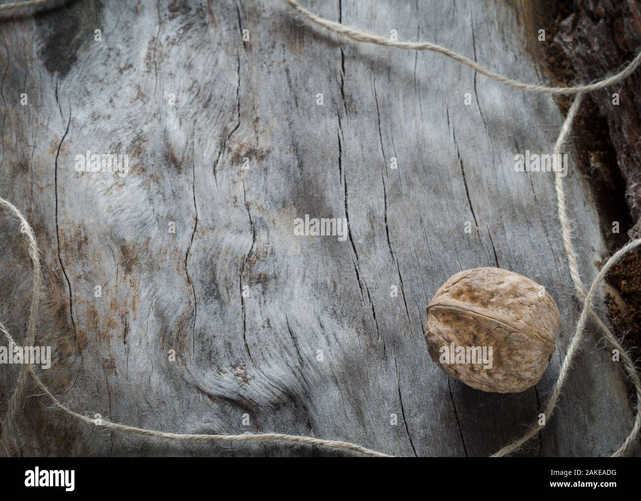 Walnuts on aged wood with twine. Closeup Stock Photo - Alamy