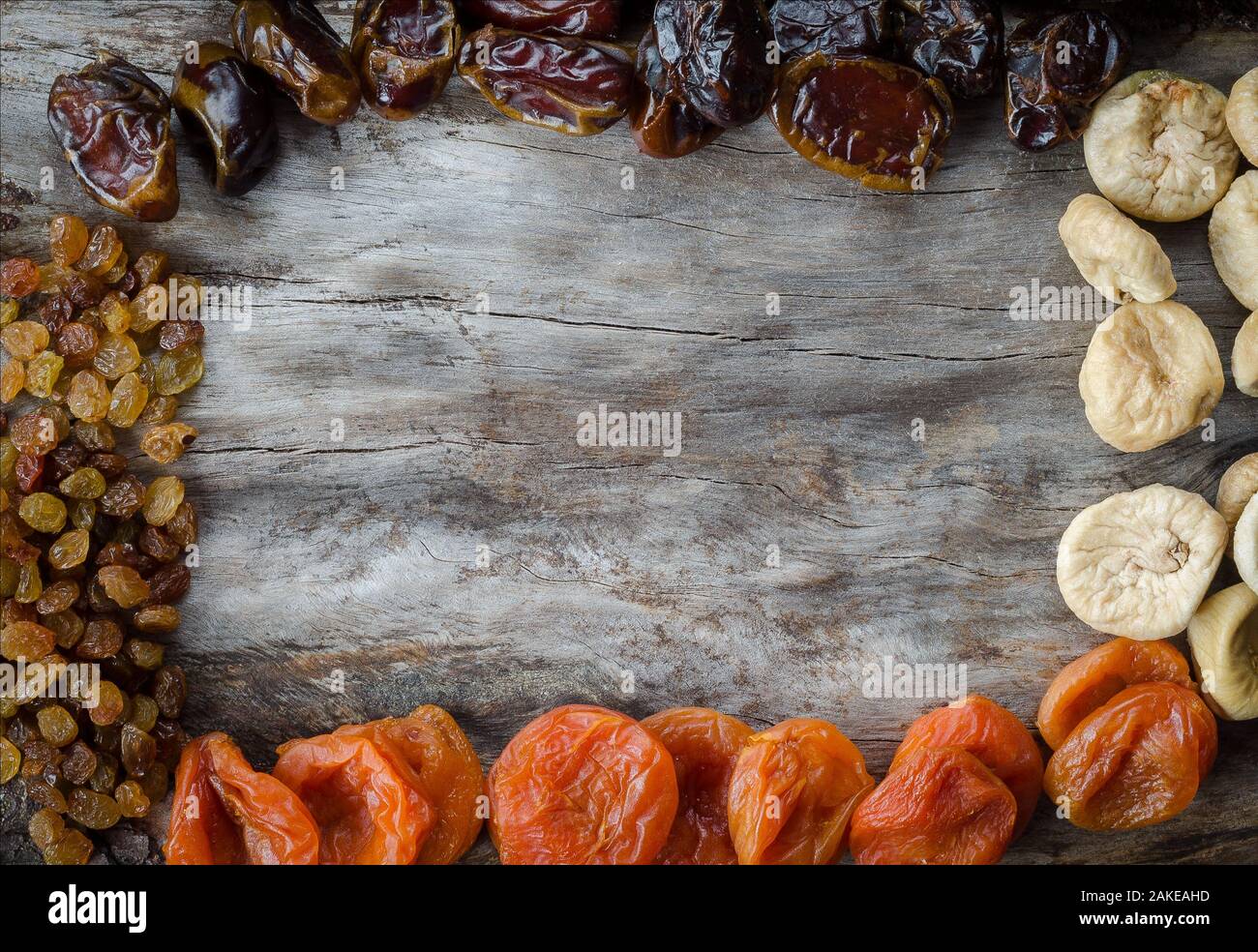 Assorted dried apricots, figs, dates and raisins on aged wood with copy ...