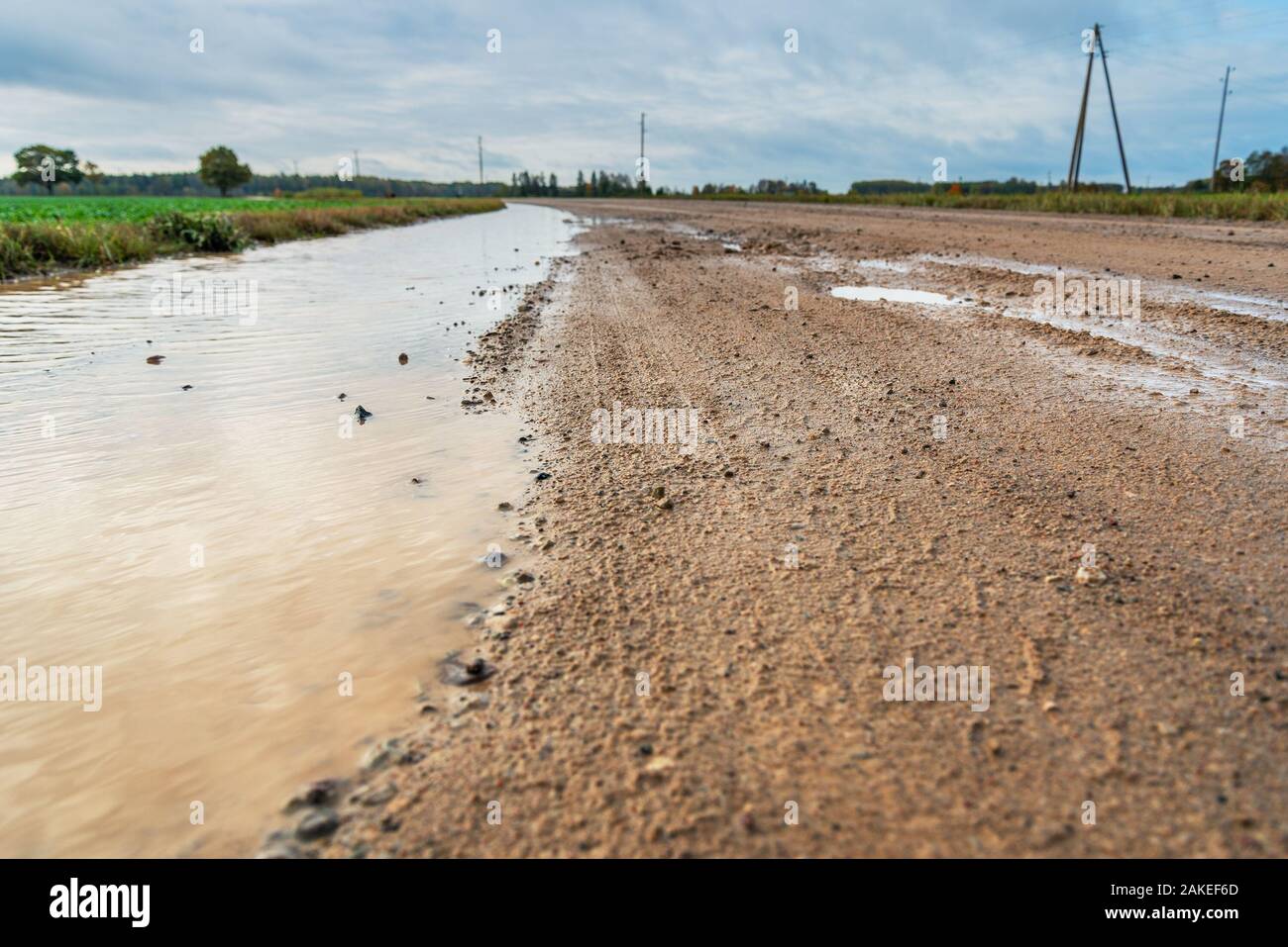 Country road with big puddle Stock Photo - Alamy