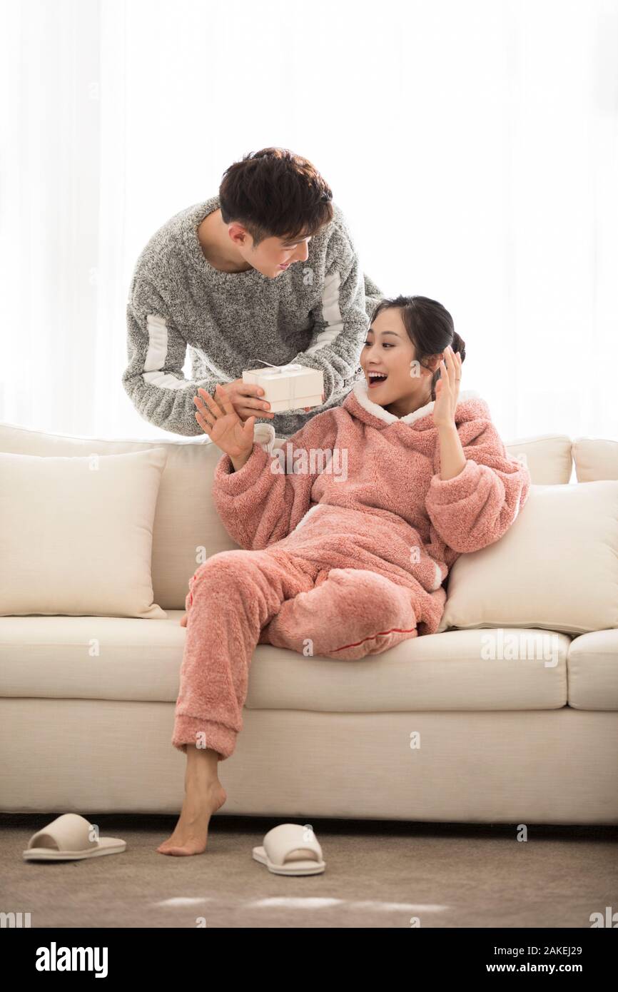 Happy young Chinese woman receiving gift from young man Stock Photo - Alamy