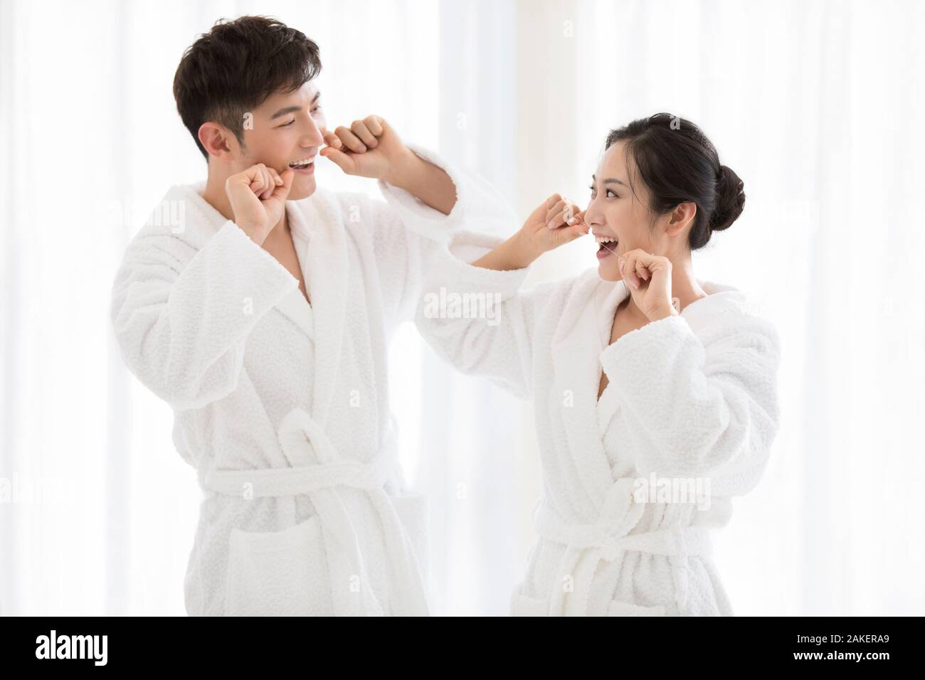 Young Chinese couple using dental floss Stock Photo - Alamy