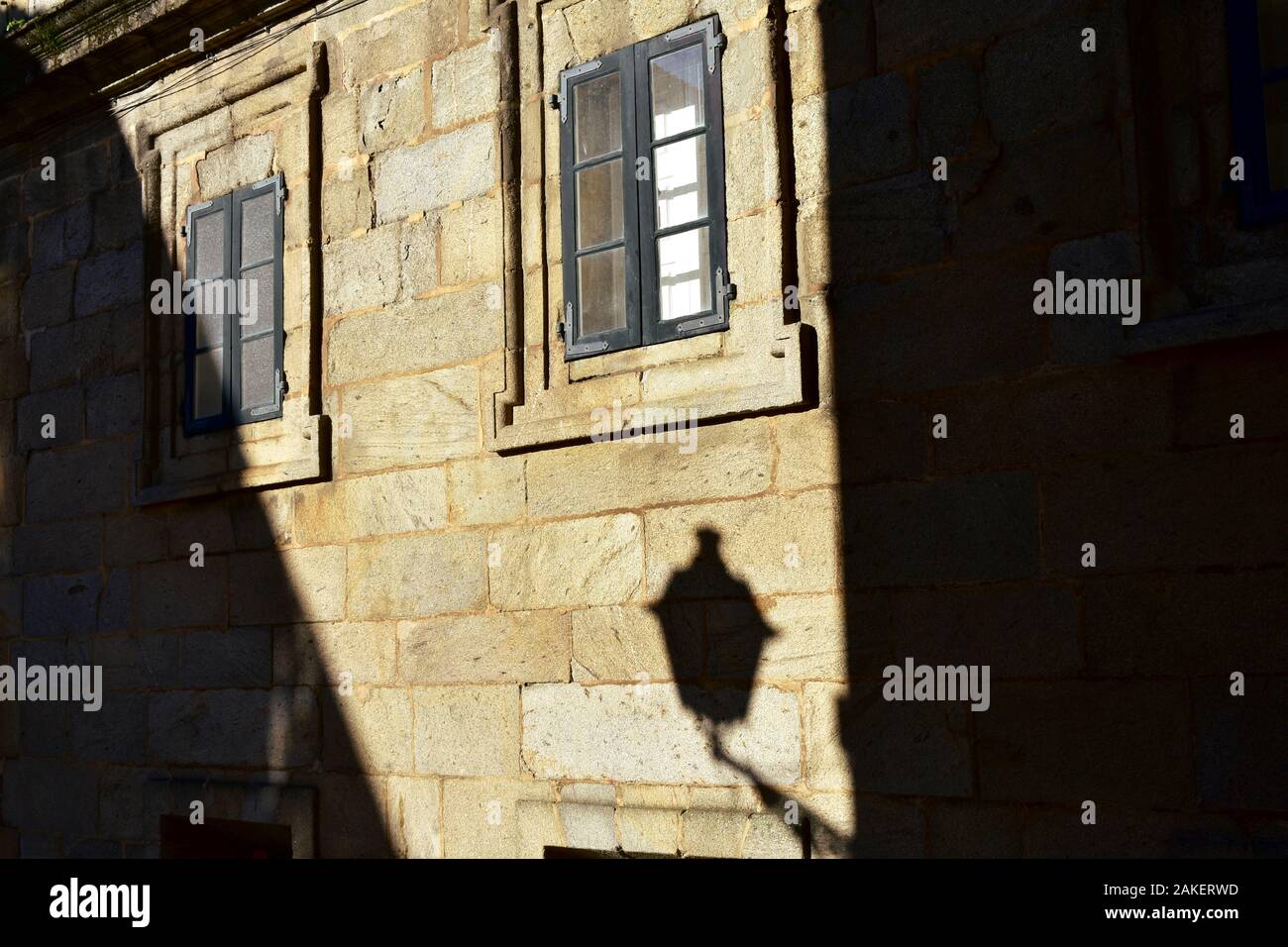 Cathedral’s wall with windows and shadow from old iron streetlight ...