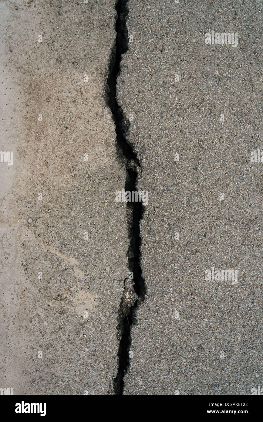 Broken asphalt road with deep split line Stock Photo - Alamy