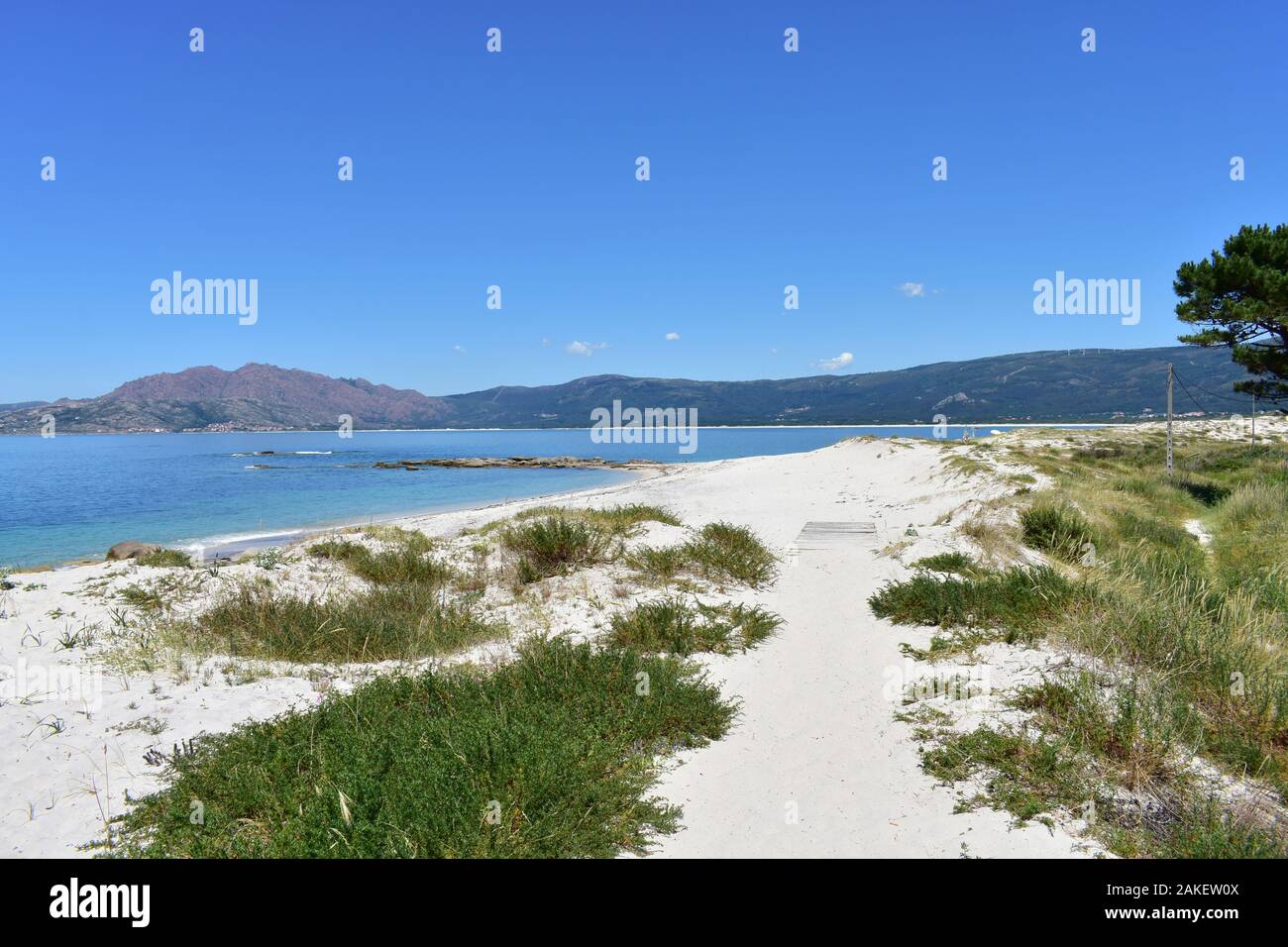 Beach with white sand and bay with turquoise water and mountain. Sand ...