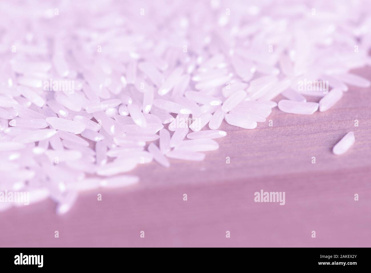White rice grains scattered on a wooden surface close up. Food ...