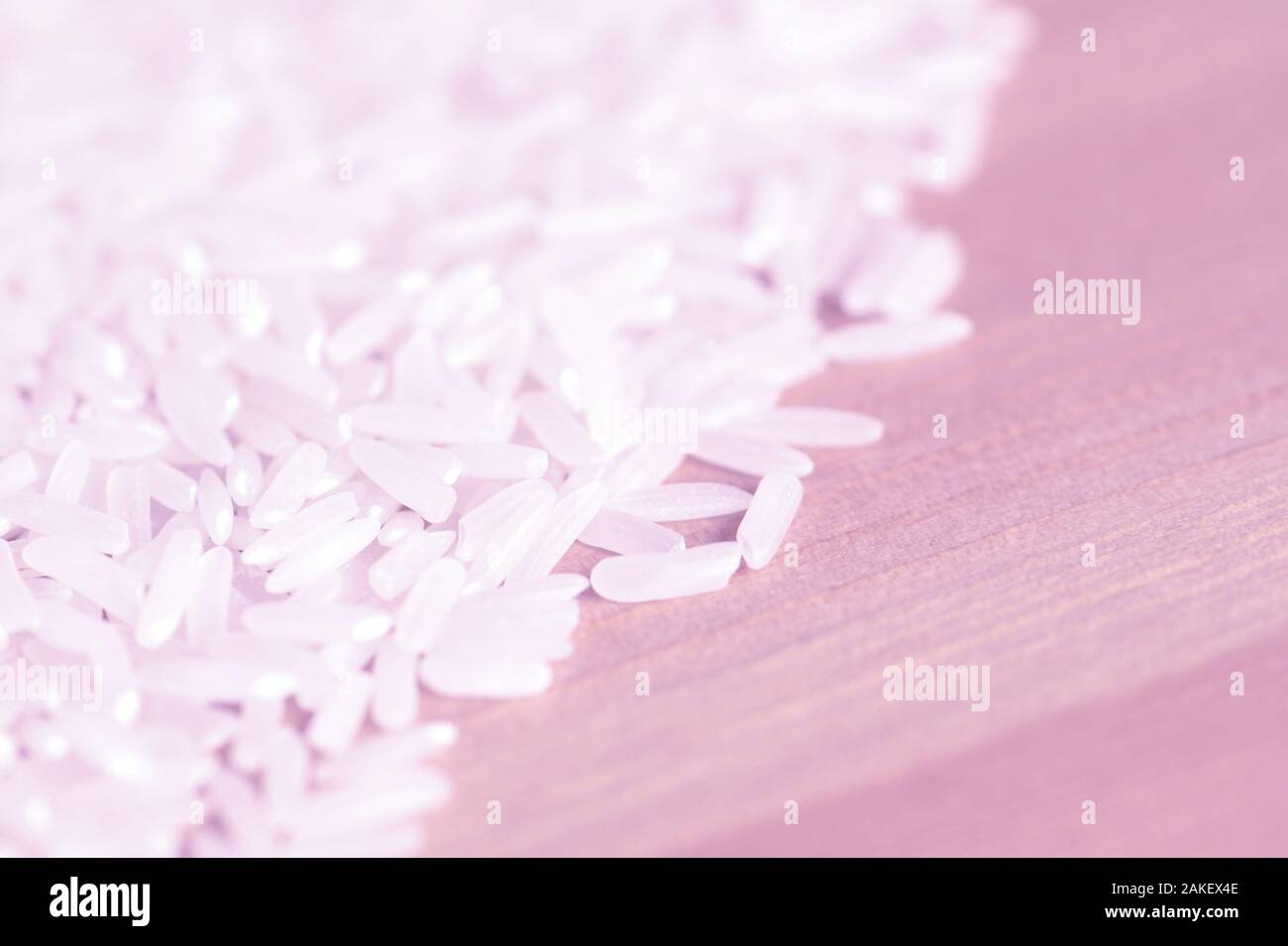 White rice grains scattered on a wooden surface close up. Food ...