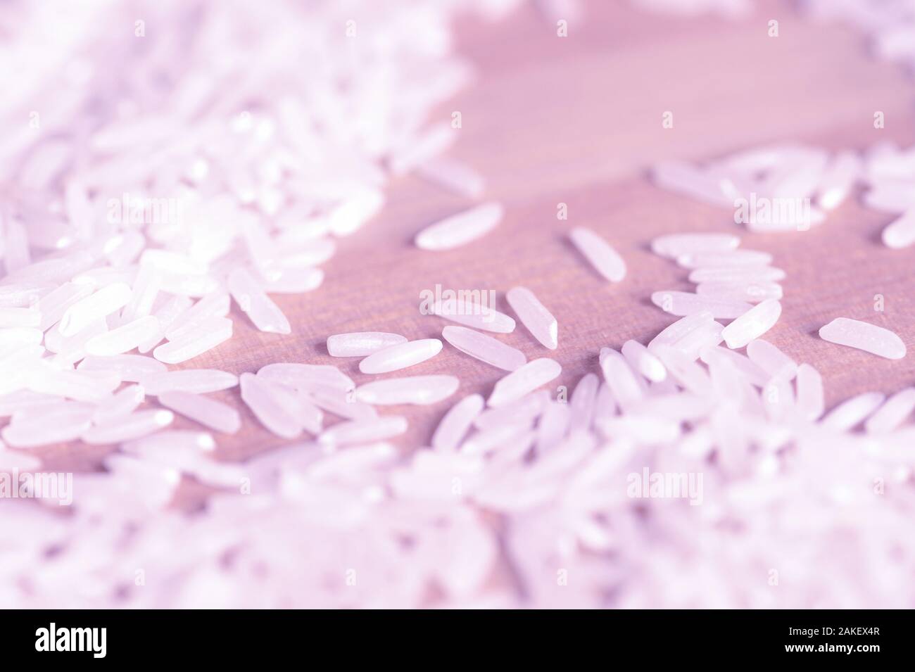 White rice grains scattered on a wooden surface close up. Food ...