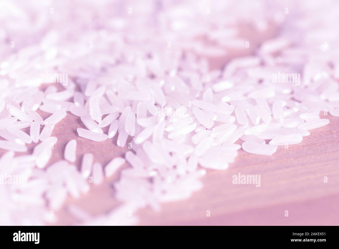 White rice grains scattered on a wooden surface close up. Food ...