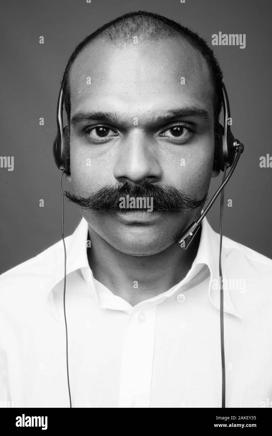 Indian businessman as call center representative against gray ...