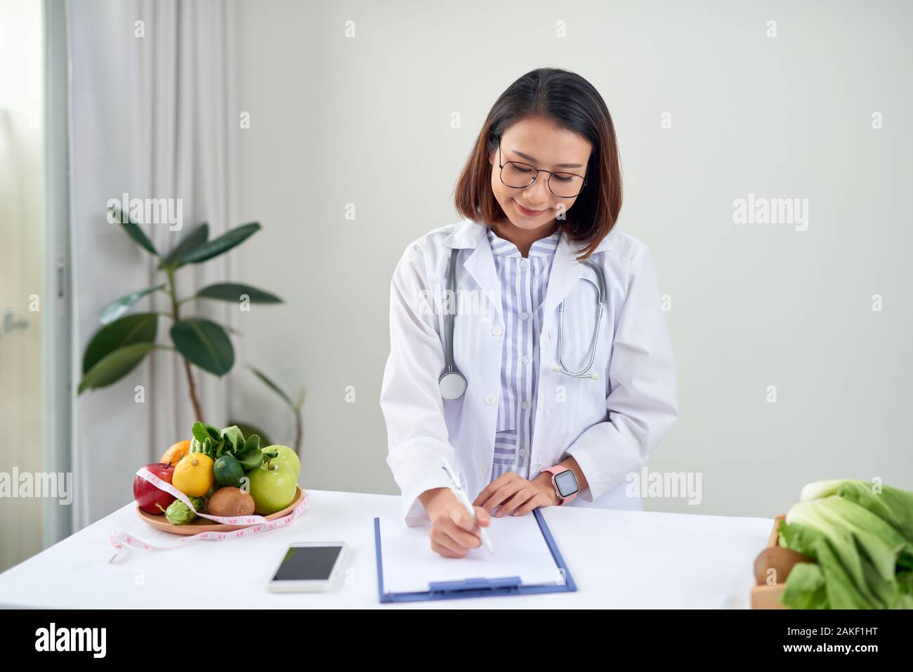 Portrait of young smiling female nutritionist in the consultation room ...