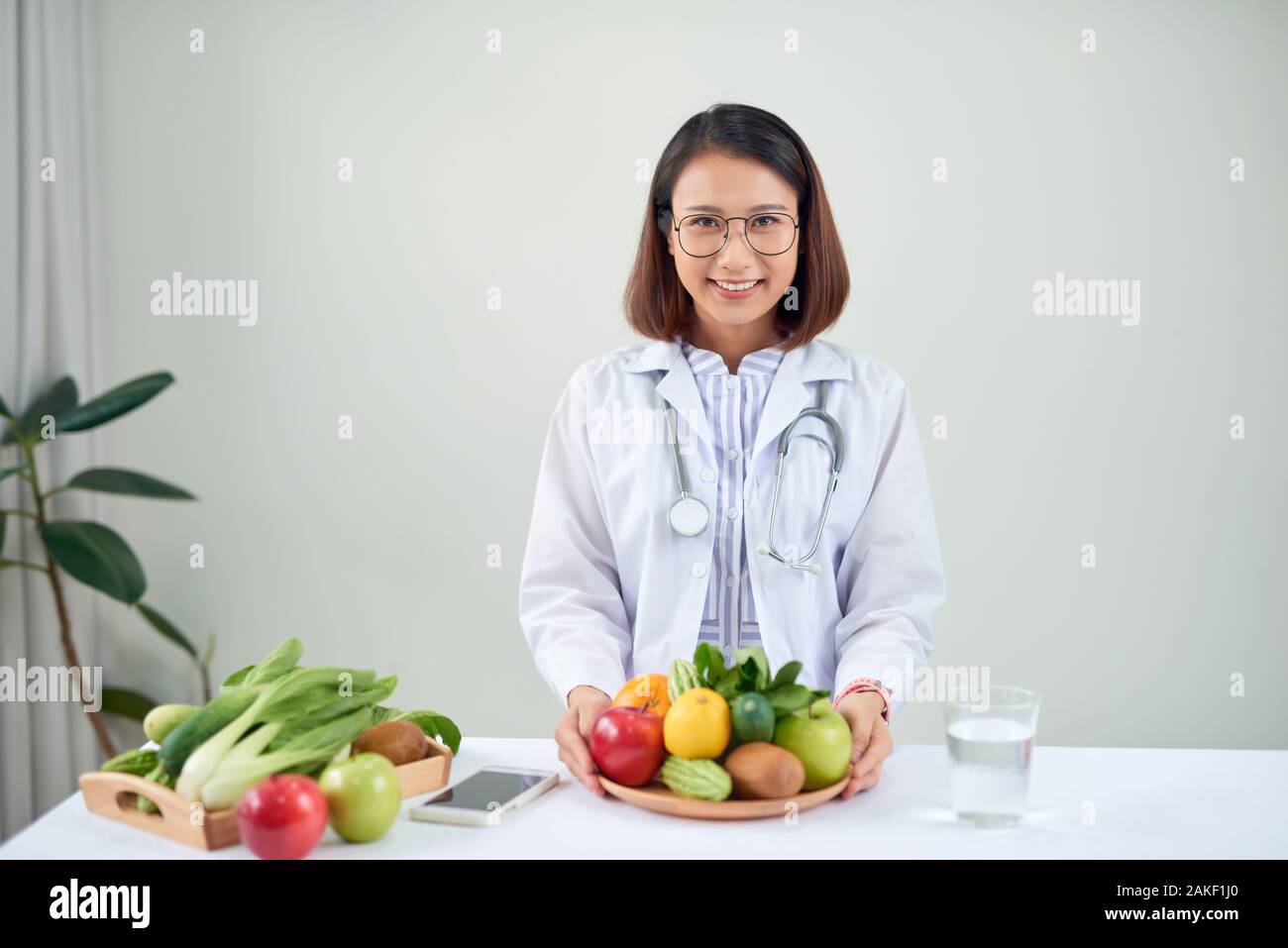 Nutritionist desk with healthy fruits, juice and measuring tape ...