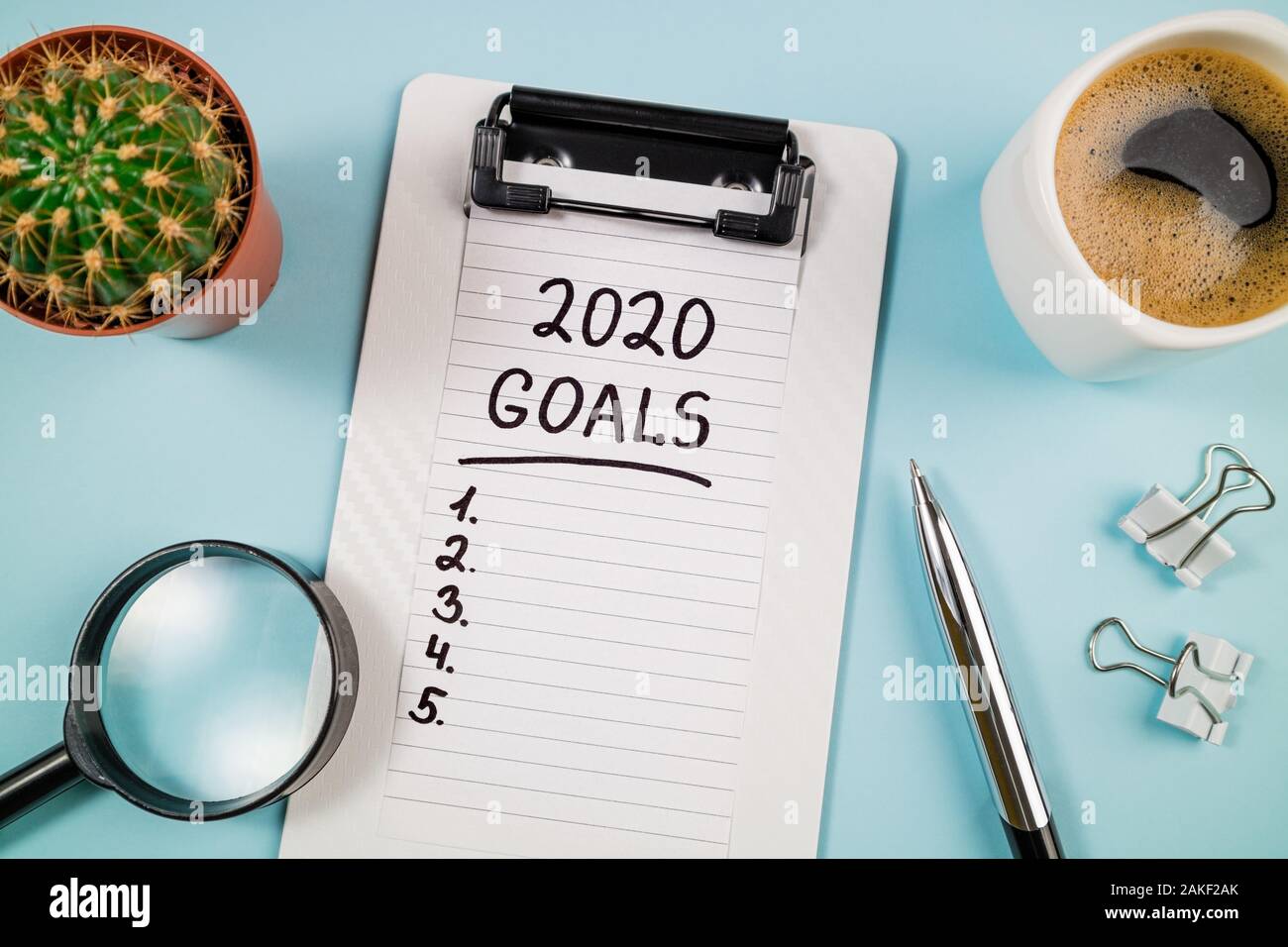 Top view 2020 new years goals list with notebook and coffee cup on blue ...