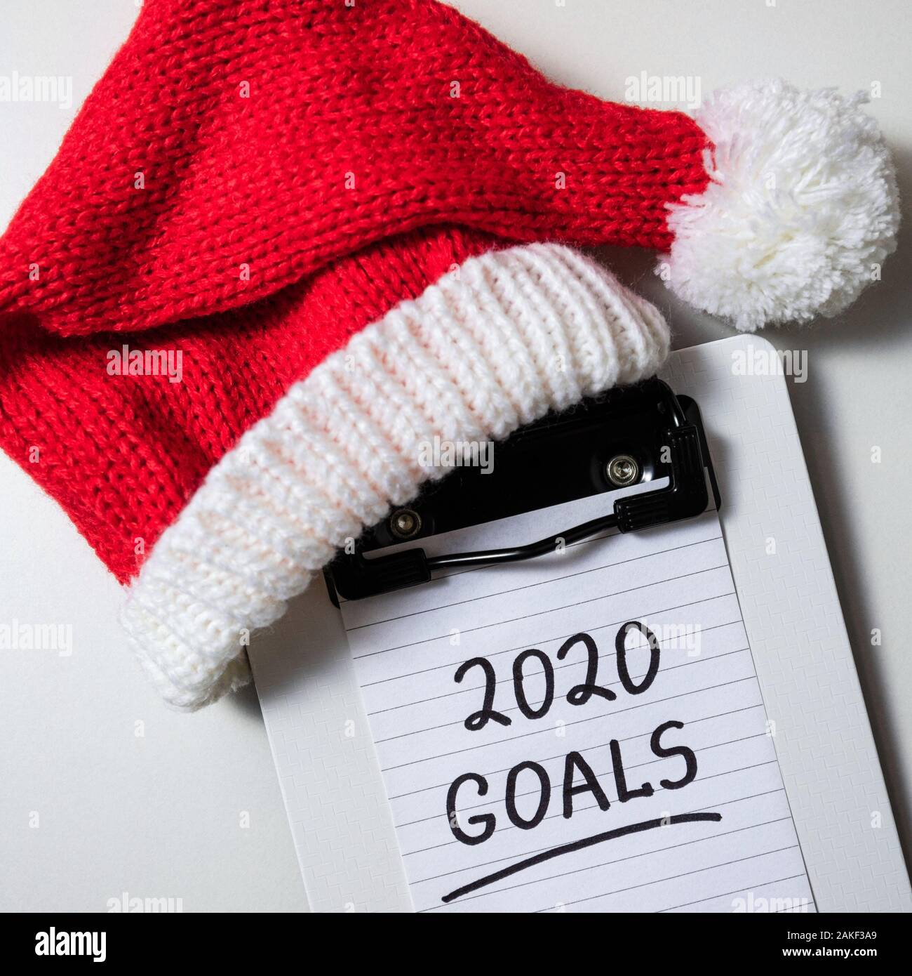 New year goals 2020 on desk. 2020 goals with notebook and red santa hat ...