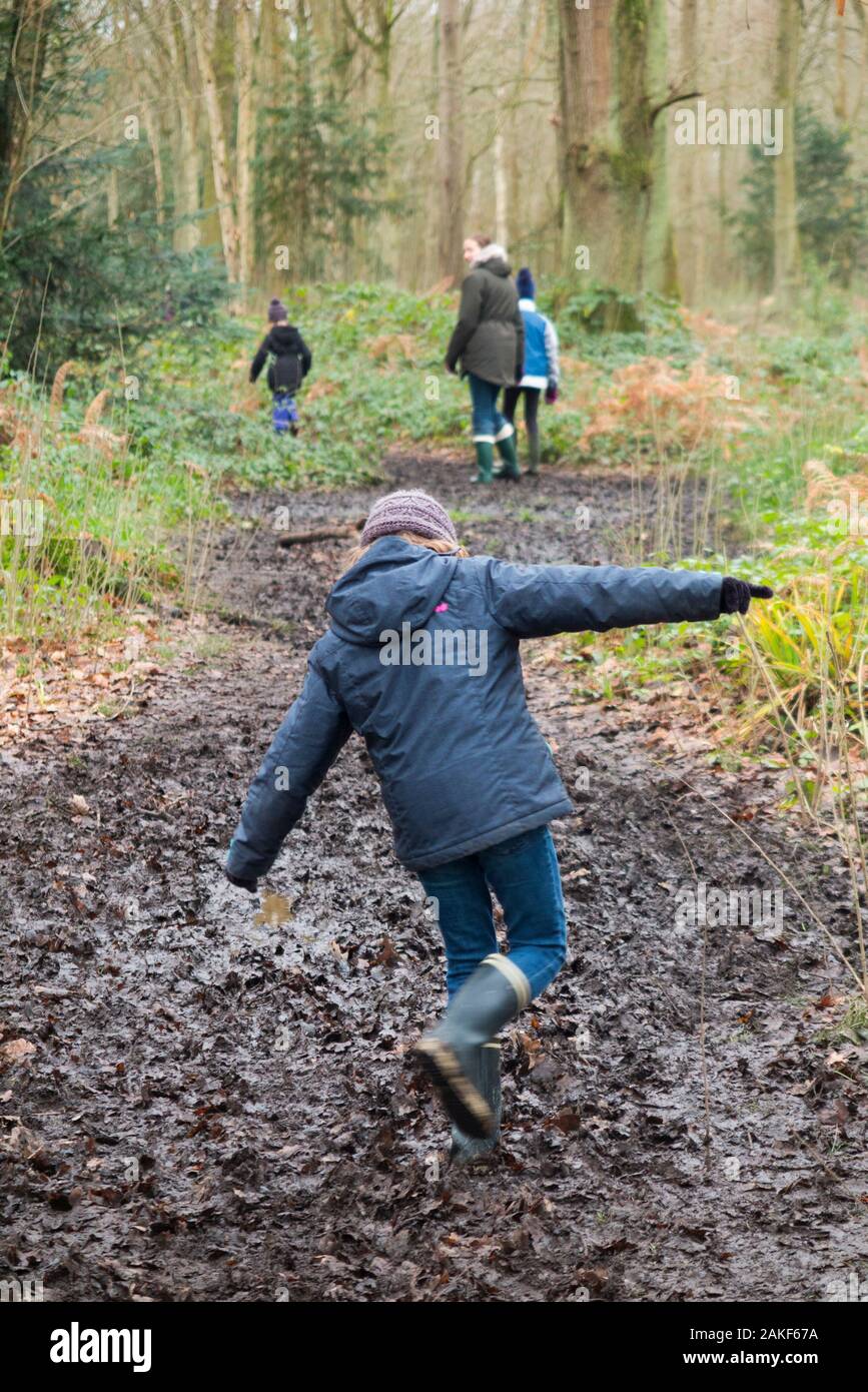 Mother / mum / mum walking through the mud with her three children on a ...