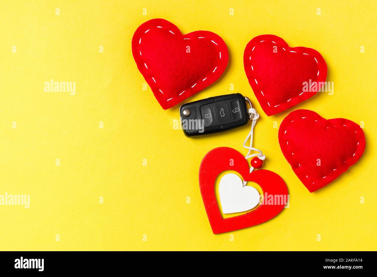 Top view of car key, wooden and textile hearts on colorful background ...