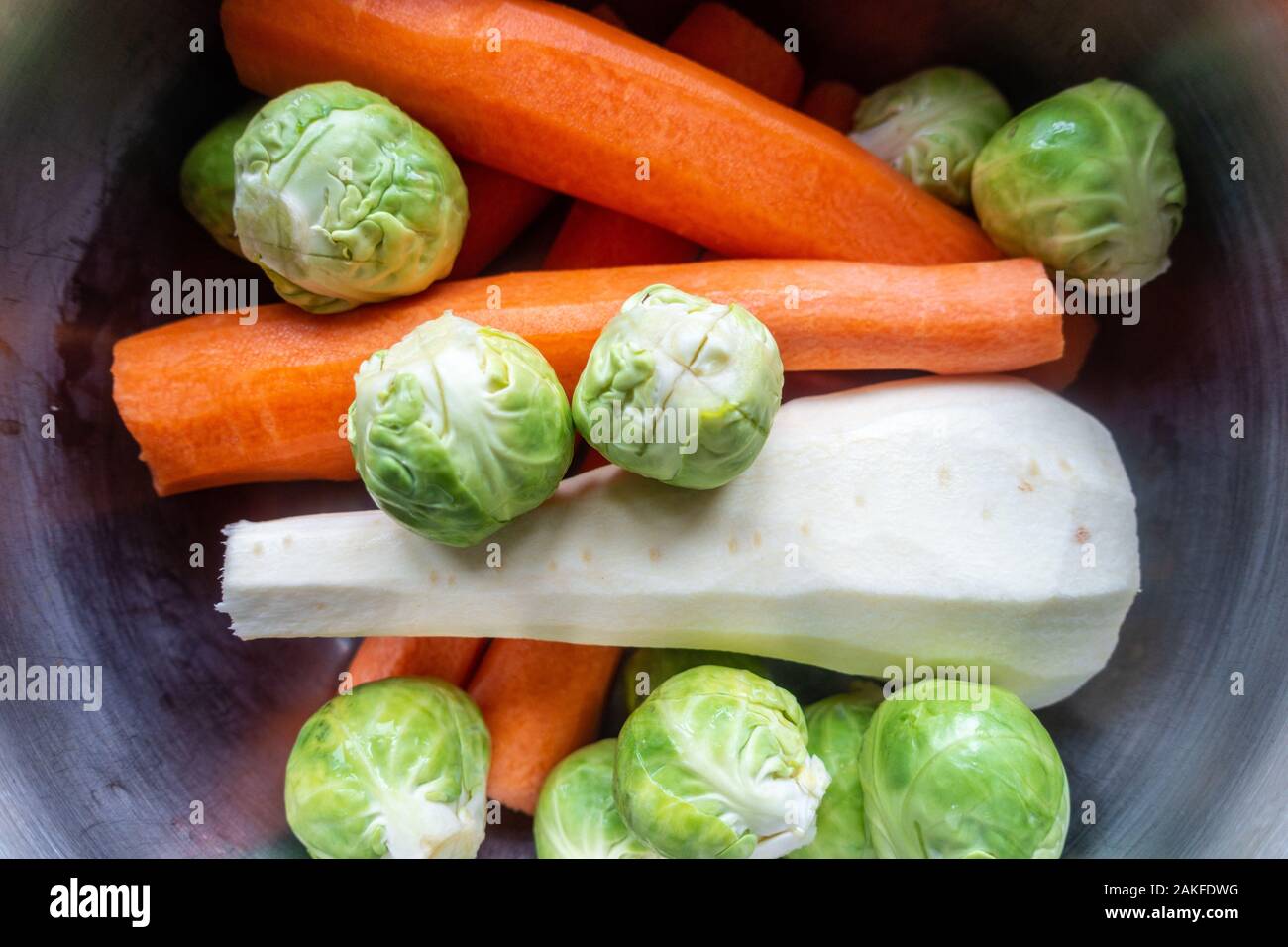 Peeled vegetables carrots, sprouts and parsnip in a pan ready to cook ...