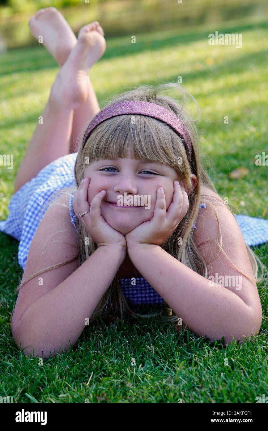 portrait of a little girl lying in the grass Stock Photo - Alamy
