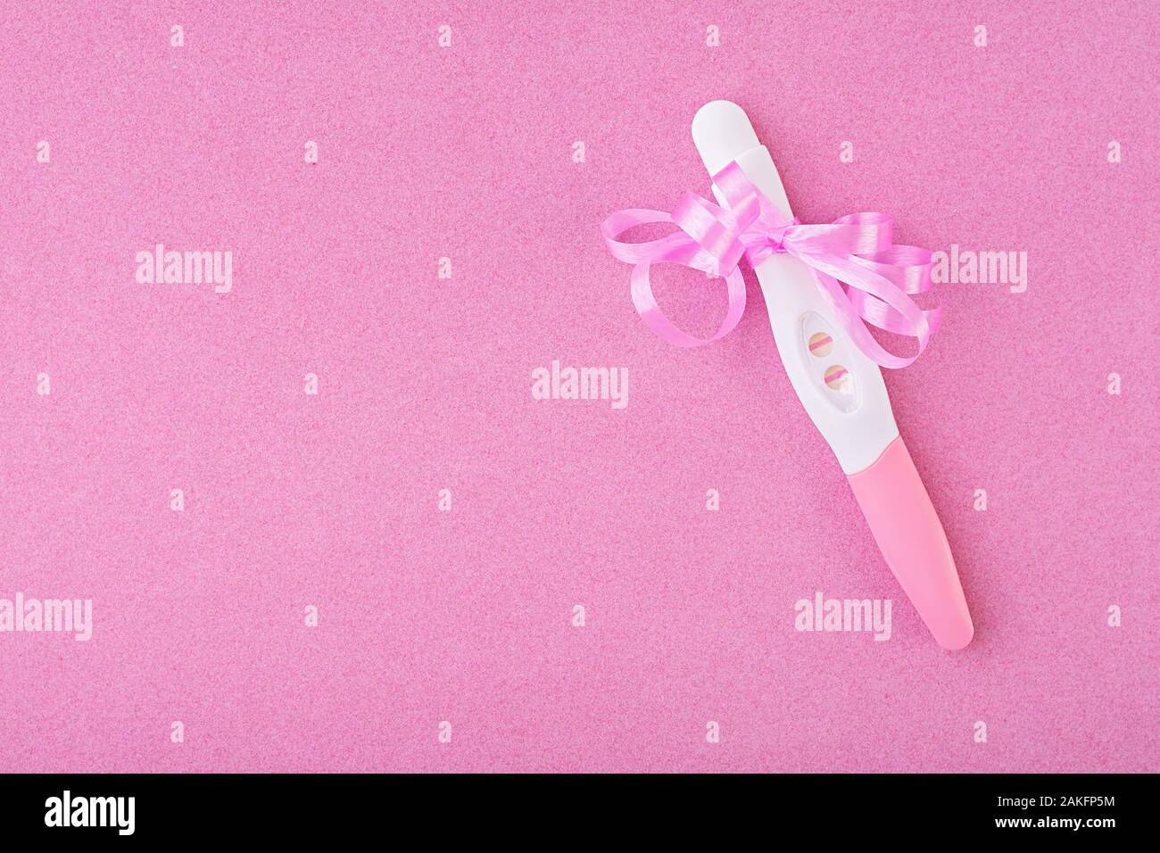 Positive pregnancy test isolated on pink background Stock Photo - Alamy