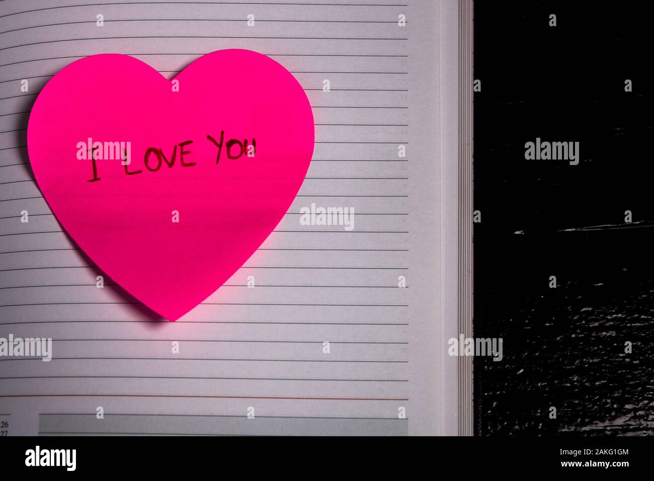 Writing I love you on memo post reminder. Text on heart shaped sticky ...