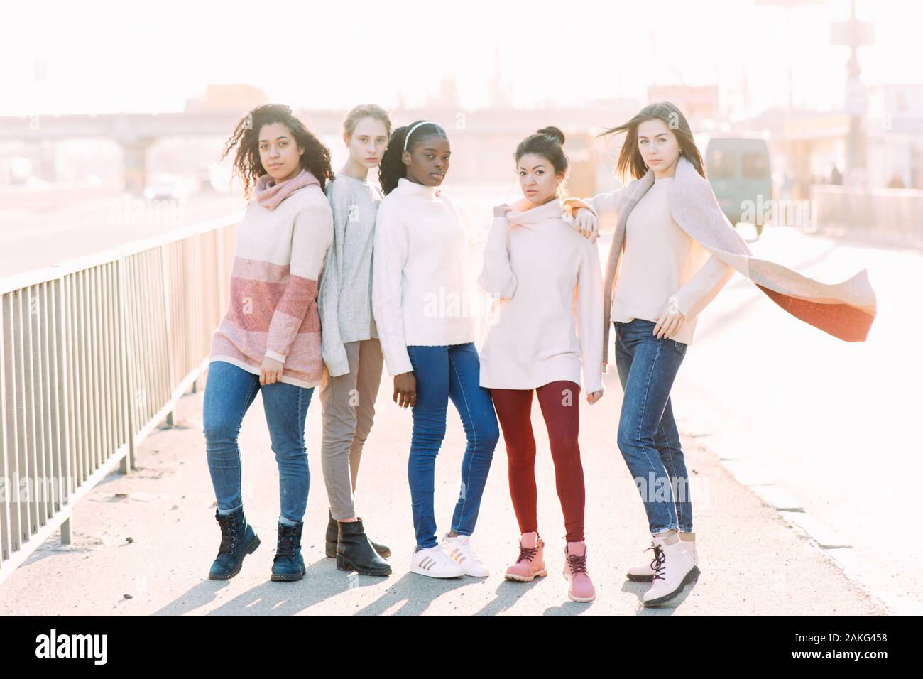 Multiracial group of friends from five young women walks on city street ...