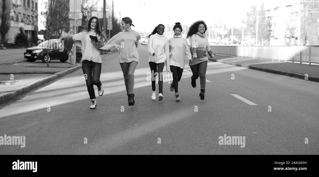 Multiracial group of friends from five young women runs and has a fun ...