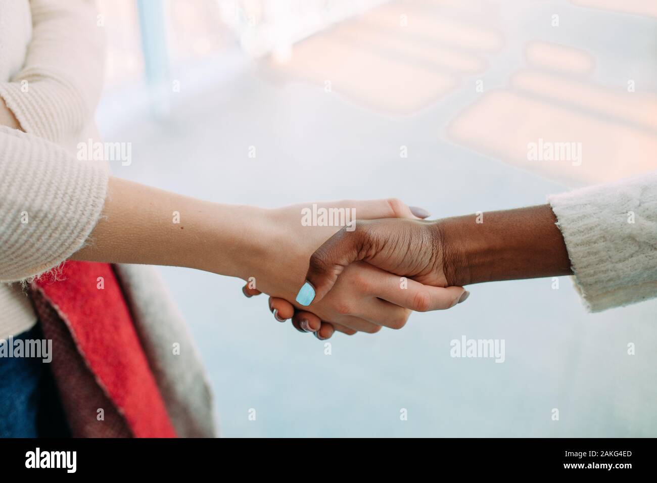 Handshake of two women of different races closeup. The concept of ...