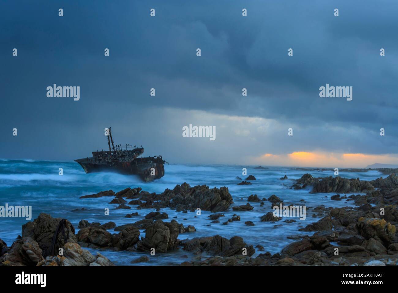 South Africa, Western Cape, sunken wreck at sunset on the rocky coast ...