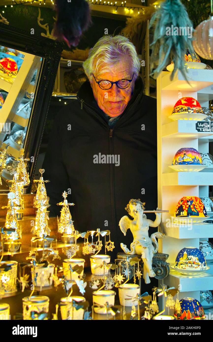 Christmas market, man selling decorative items, angels,,man in booth ...