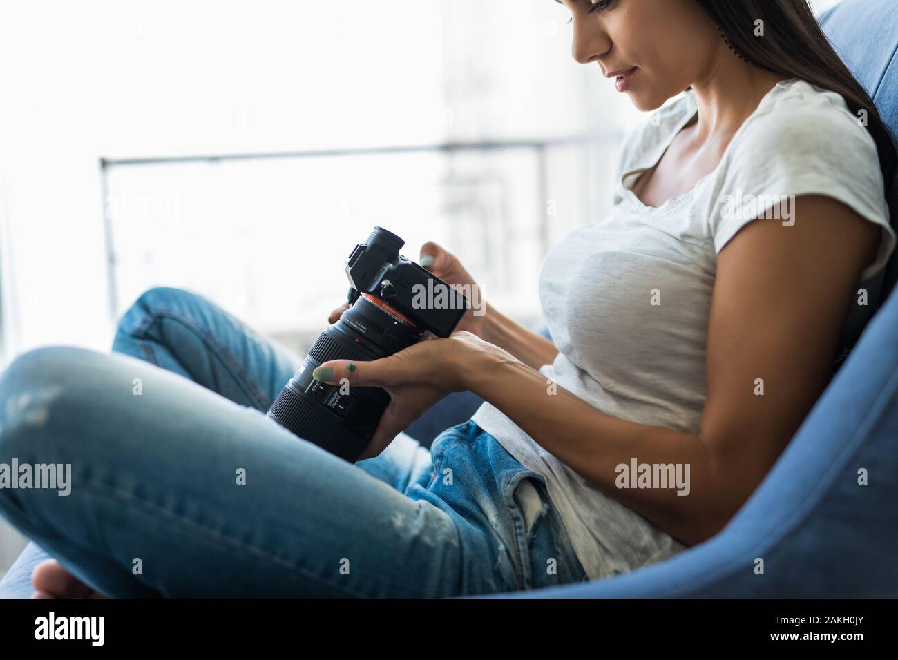 Attractive female photographer sitting back in her chair smiling in ...