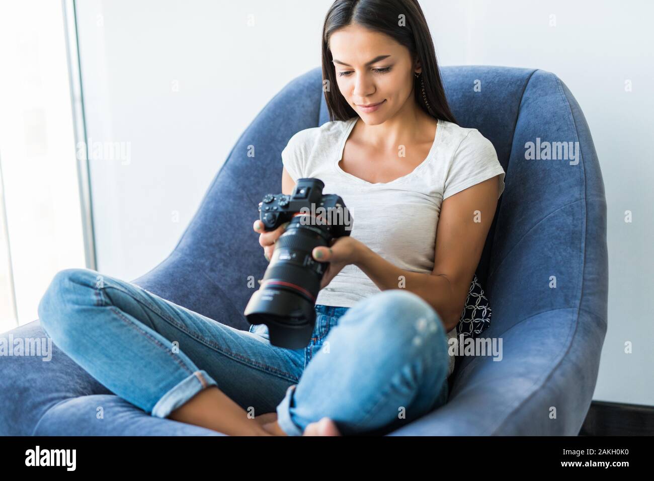 Attractive female photographer sitting back in her chair smiling in ...