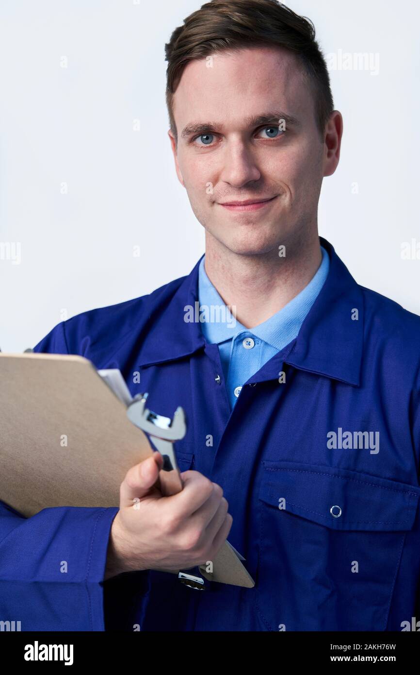 Studio Portrait Of Male Engineer With Clipboard And Spanner Against ...