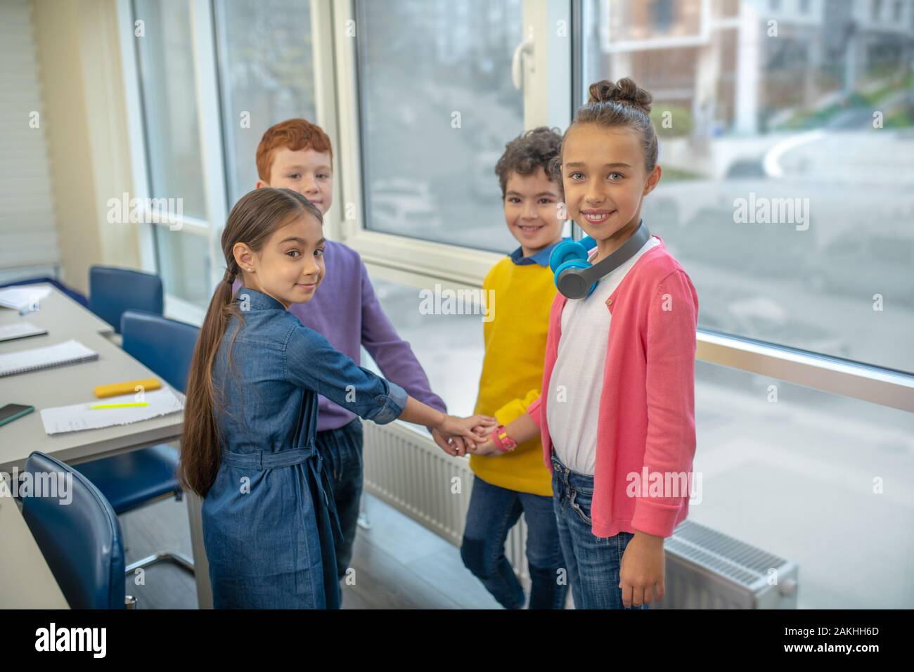 Happy school children preparing to work in team Stock Photo - Alamy