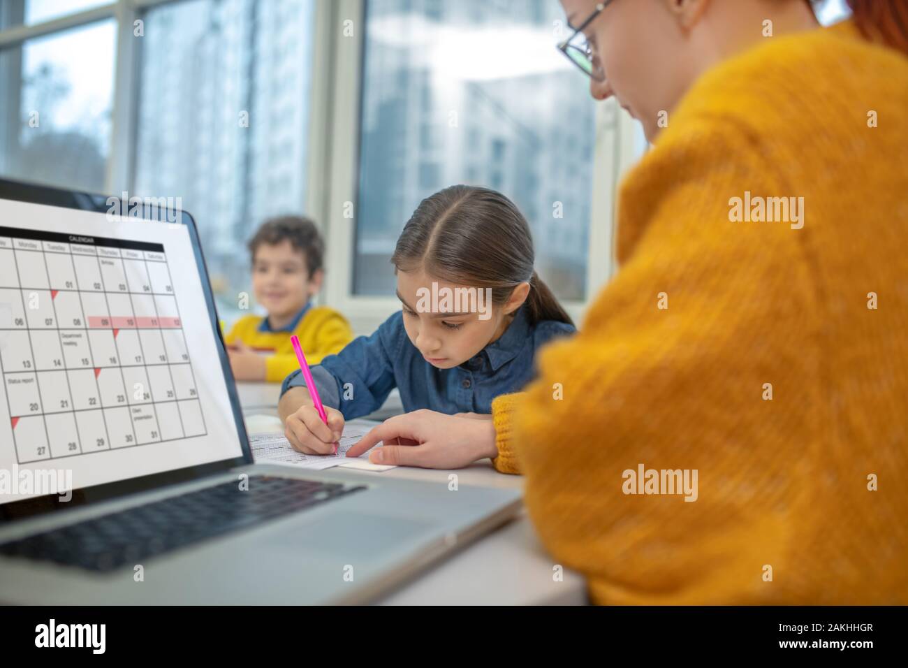 Teacher giving a task to one of her pupils Stock Photo - Alamy