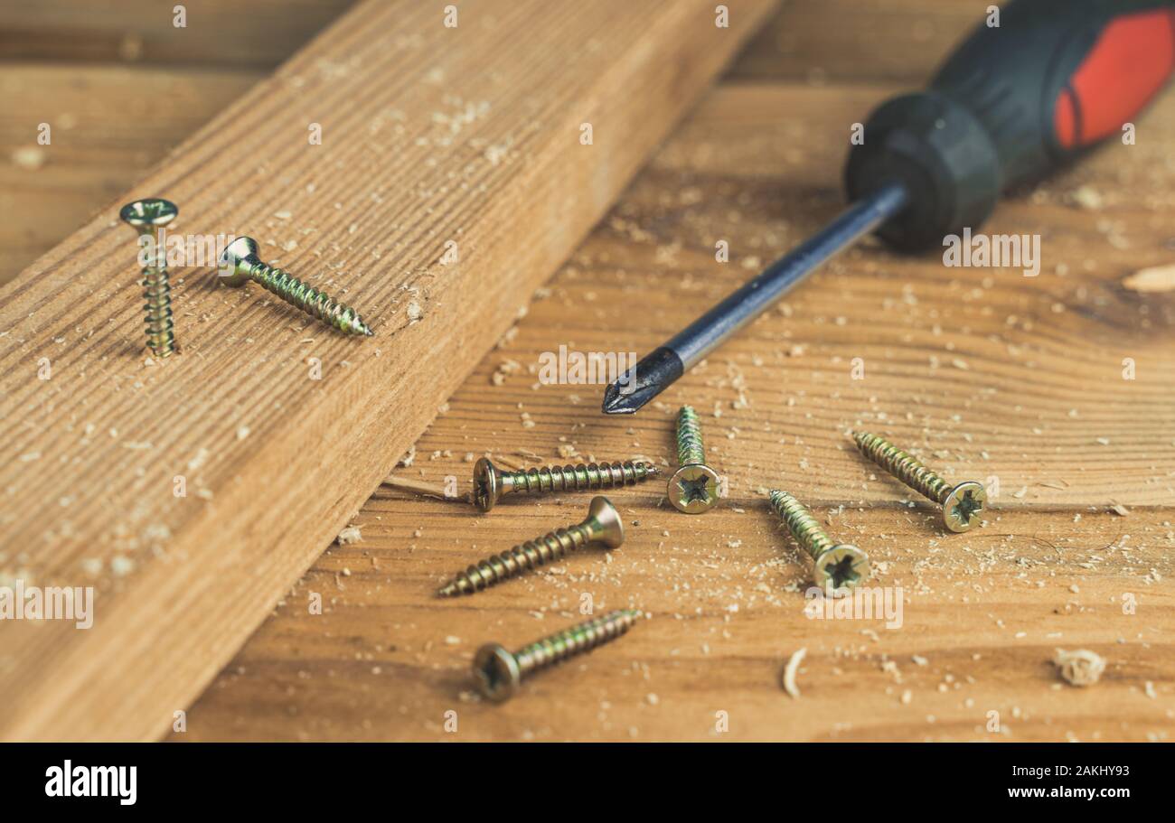 Screws, screwdriver, ruler and a pencil on a wood table. Concept tools ...