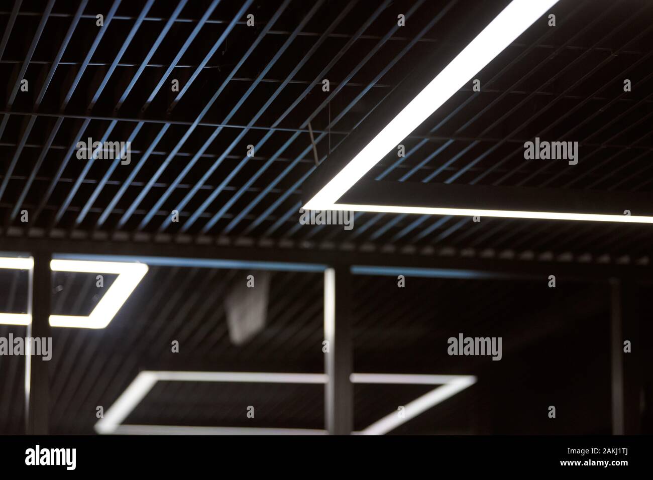 Modern office lighting. Thin lamps in office dark ceiling. LED white ...