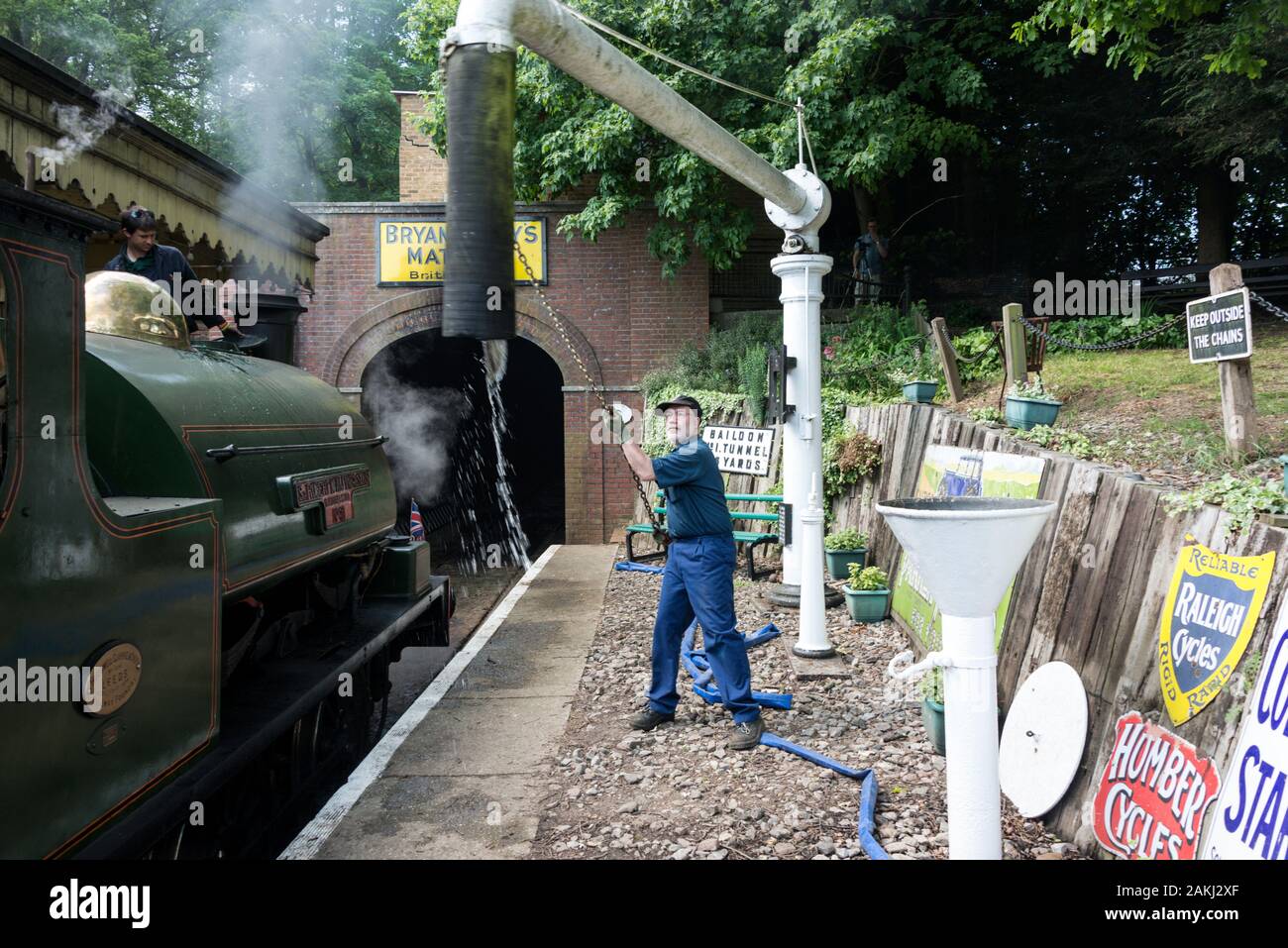 Water is being fed into the steam locomotive by volunteers at the ...