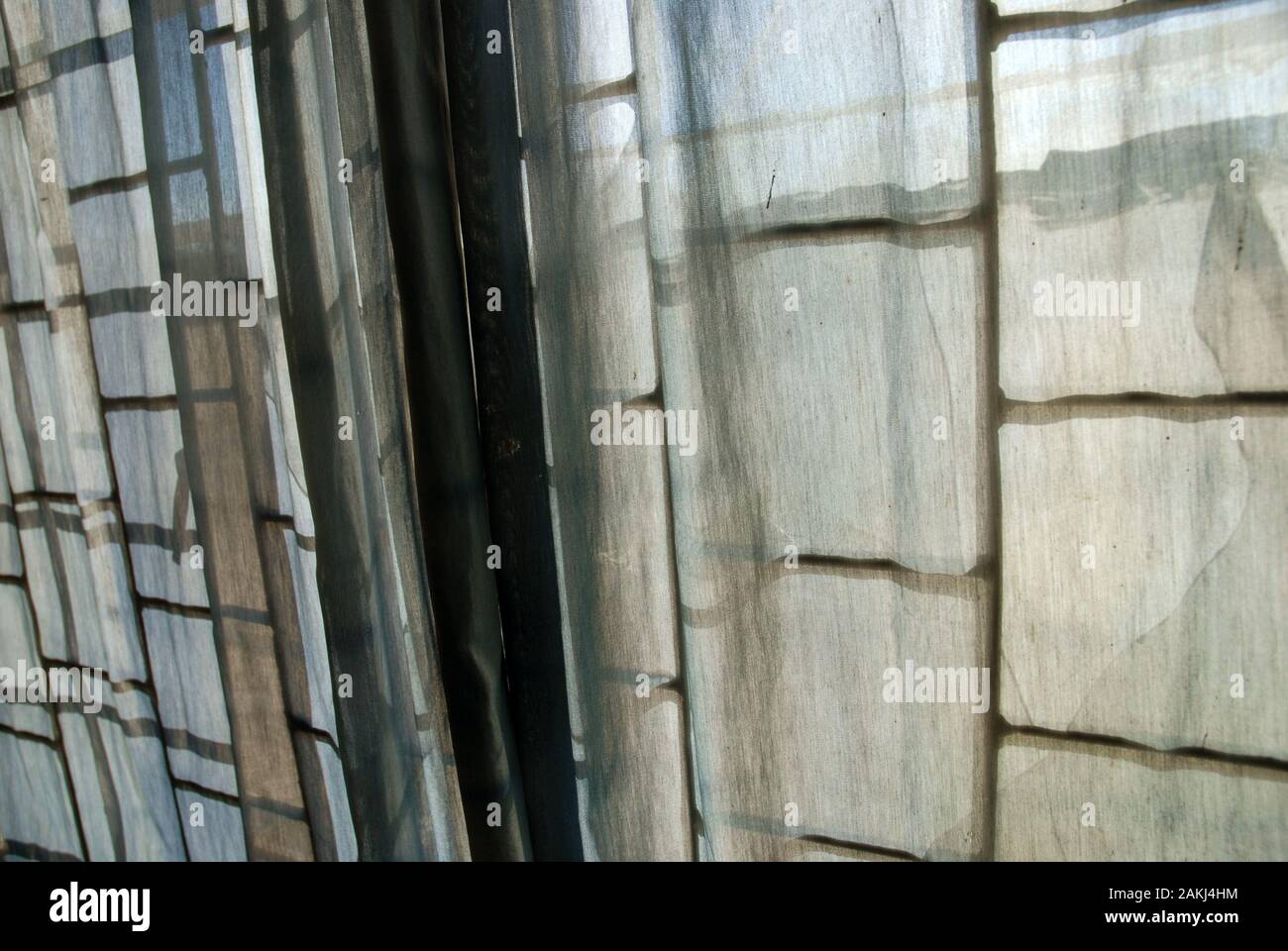 Old net curtains at a shuttered window in abandoned post office, Mwandi ...