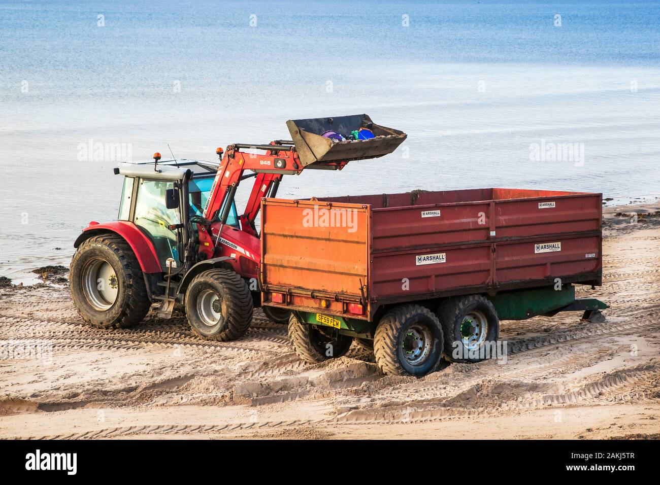 Tractor and trailer being used to clean the pollution and rubbish from ...