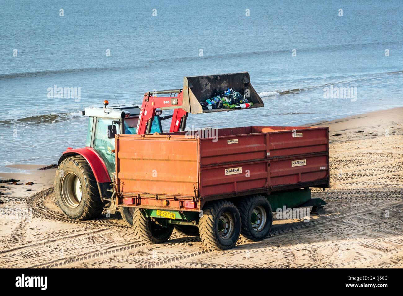 Tractor and trailer being used to clean the pollution and rubbish from ...