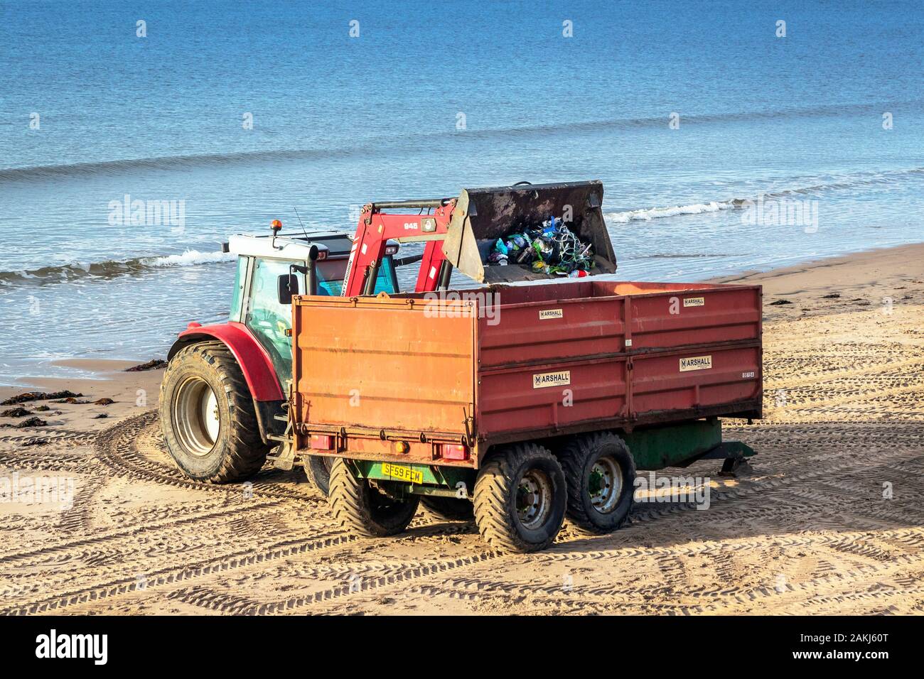 Tractor and trailer being used to clean the pollution and rubbish from ...