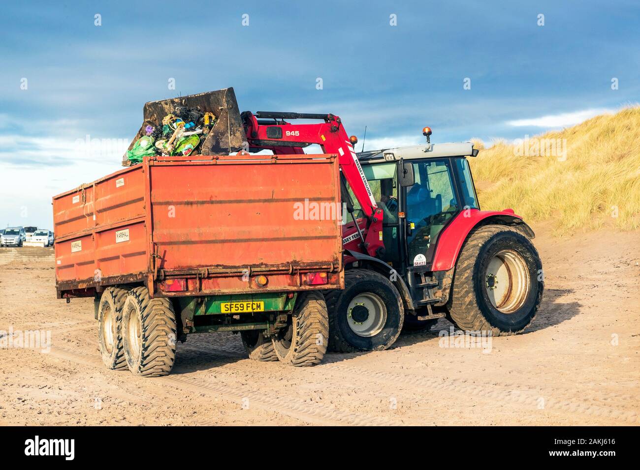 Tractor and trailer being used to clean the pollution and rubbish from ...
